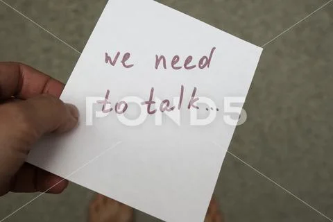 Woman holding a piece of paper with hand written frase, message We need ...