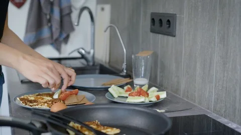 A woman is laying out breakfast on a pla... | Stock Video | Pond5