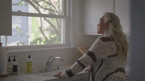 Woman Looking Out Kitchen Window | Stock Video | Pond5