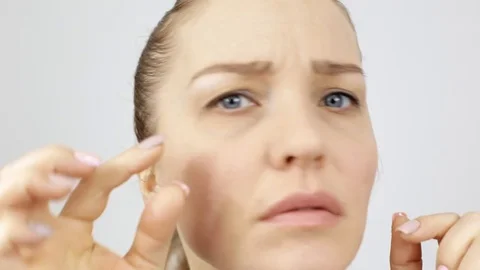 woman looks critically at the skin on he... | Stock Video | Pond5
