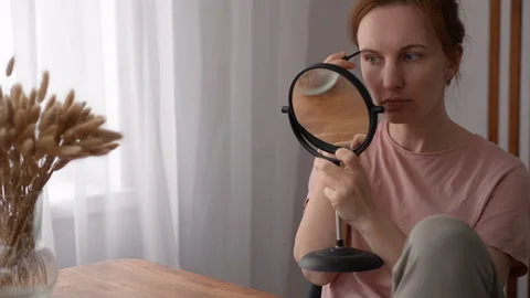 A woman looks in the mirror while groomi... | Stock Video | Pond5
