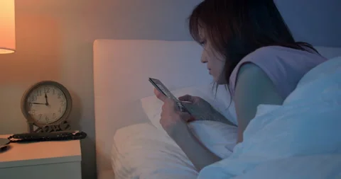 Woman lying in bed check cell phone befo... | Stock Video | Pond5