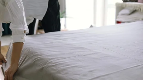 Woman makes the bed, fluffing soft pillo... | Stock Video | Pond5