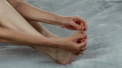 Woman massages her toes using a moisturi... | Stock Video | Pond5
