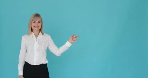 Woman Pointing Right with a Smile on Blu... | Stock Video | Pond5