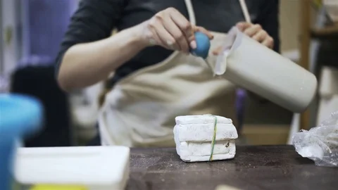 Woman pouring gypsum into cast | Stock Video | Pond5