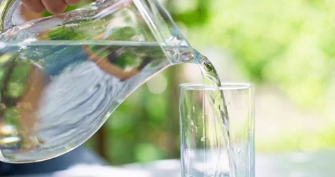 A woman pouring pure water into glass fr... | Stock Video | Pond5
