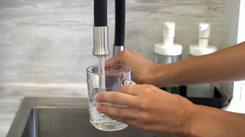 Woman pouring a tap water in empty glass... | Stock Video | Pond5