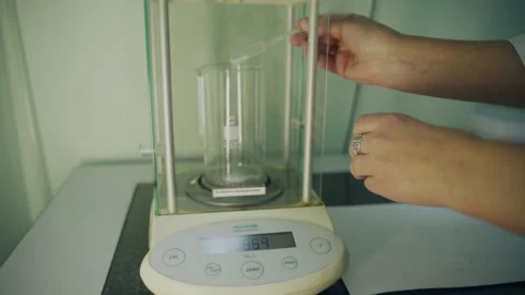 Woman pours white powder into beaker on ... | Stock Video | Pond5