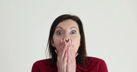 Woman puts hands on face with open mouth... | Stock Video | Pond5