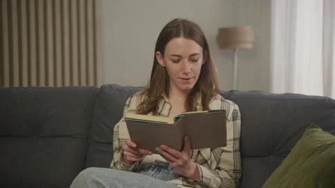 Woman Reading a Book in Apartment | Stock Video | Pond5