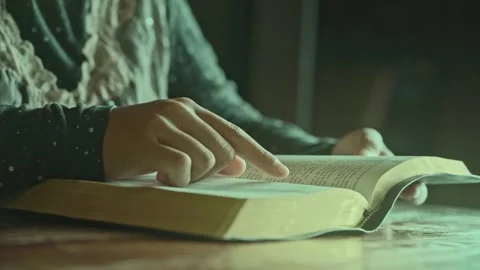 a woman reading a a book bible using han... | Stock Video | Pond5
