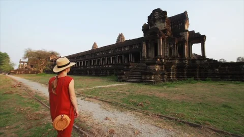 Woman in red dress walks to the Angkor W... | Stock Video | Pond5