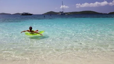 woman relaxing in raft on tropical beach... | Stock Video | Pond5