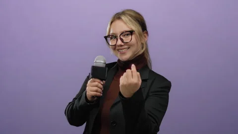Woman reporter with glasses holds a micr... | Stock Video | Pond5