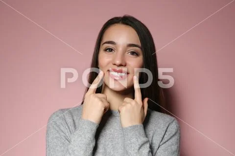 Woman showing LAUGH gesture in sign language on color background ...