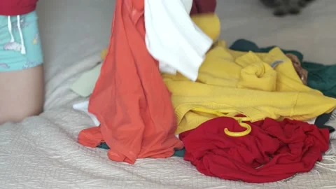 woman sorting through pile of clothes, t... | Stock Video | Pond5