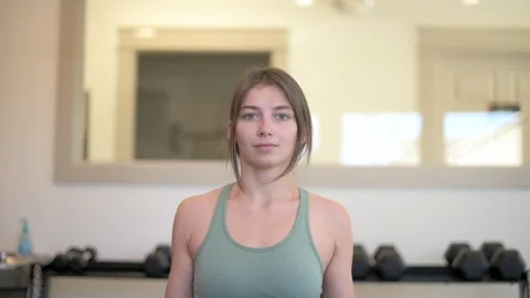 A woman in a sports bra lifting a dumbbe... | Stock Video | Pond5
