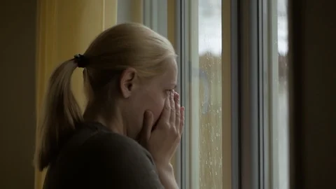 Woman standing at the window in the room... | Stock Video | Pond5