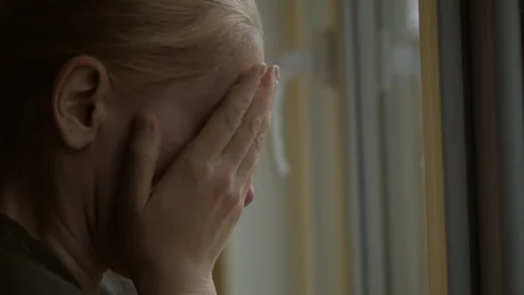 Woman standing at the window in the room... | Stock Video | Pond5