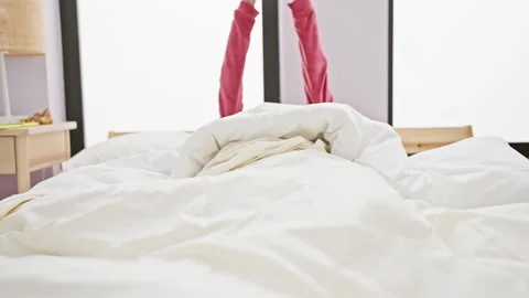 A woman stretches in bed, signaling a mo... | Stock Video | Pond5