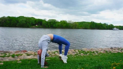woman stretches standing in bridge posit... | Stock Video | Pond5