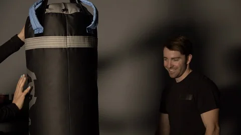 Woman supporting punching bag as man hit... | Stock Video | Pond5