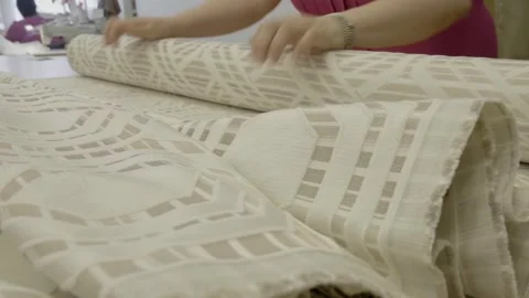 Woman tailor unwrapping fabric from roll | Stock Video | Pond5
