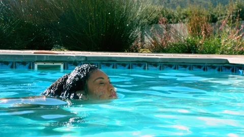 Woman takes a dip in swimming pool on a ... | Stock Video | Pond5