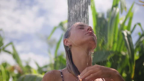 Woman takes a shower with fresh water on... | Stock Video | Pond5