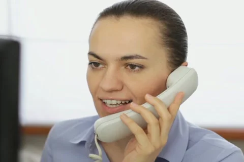 Woman talking on landline phone in front... | Stock Video | Pond5