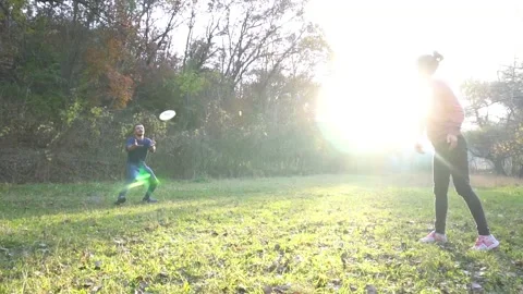 Woman throws a disc, friend waiting on b... | Stock Video | Pond5
