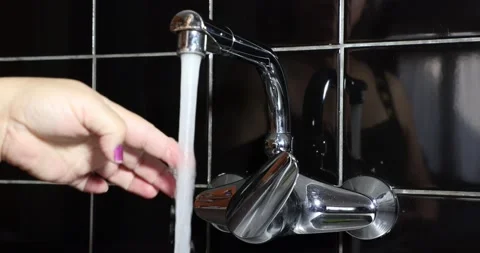 Woman turning kitchen faucet on and off,... | Stock Video | Pond5