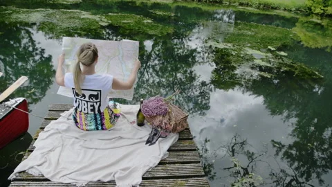 Woman unfolding map of area to look at n... | Stock Video | Pond5