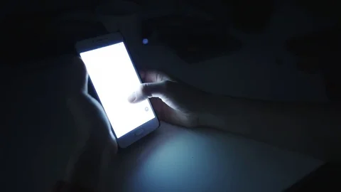Woman uses a smart phone in a dark room | Stock Video | Pond5