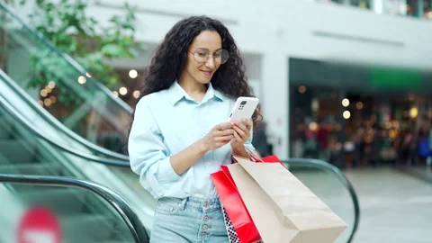 A woman uses a smartphone in a shopping ... | Stock Video | Pond5