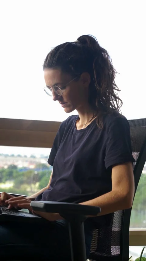Woman using a computer sitting on a chai... | Stock Video | Pond5