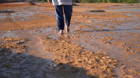Woman walking barefoot in the mud | Stock Video | Pond5