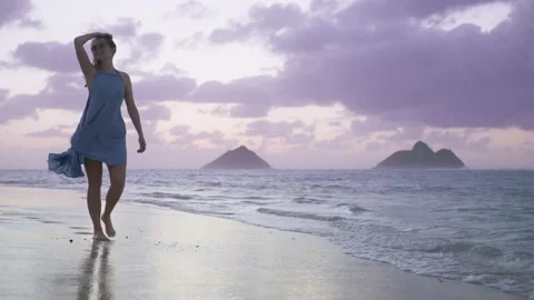 Woman walking by ocean beach, raising ar... | Stock Video | Pond5
