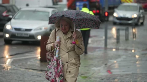 Woman walking & shopping in rain with um... | Stock Video | Pond5