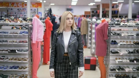 Woman walks between the rows of clothes ... | Stock Video | Pond5