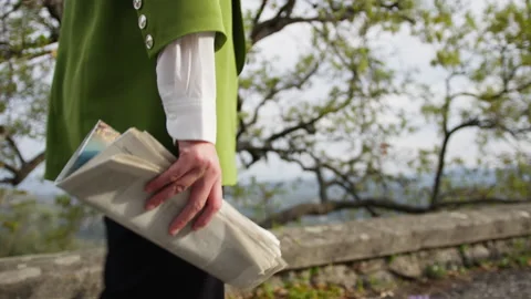 Woman walks with newspaper in hand | Stock Video | Pond5