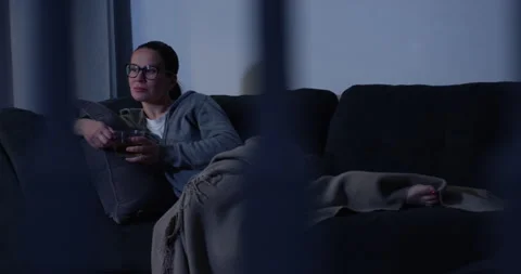 Woman watching TV alone at home at night... | Stock Video | Pond5