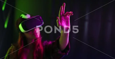 Photograph: Woman wearing a VR headset, interacting with objects in the ...