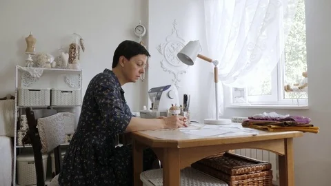 Woman is working with sewing patterns on... | Stock Video | Pond5