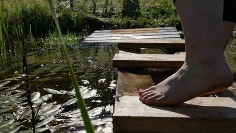 Woman's Foot Crossing Water Sunken Dock | Stock Video | Pond5