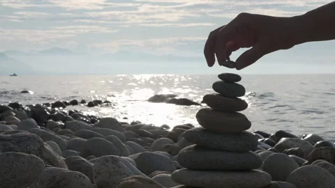 Woman's hand making pyramid of stones fo... | Stock Video | Pond5