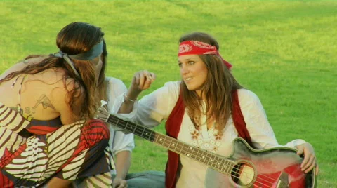 Women dressed like hippies sit in the gr... | Stock Video | Pond5
