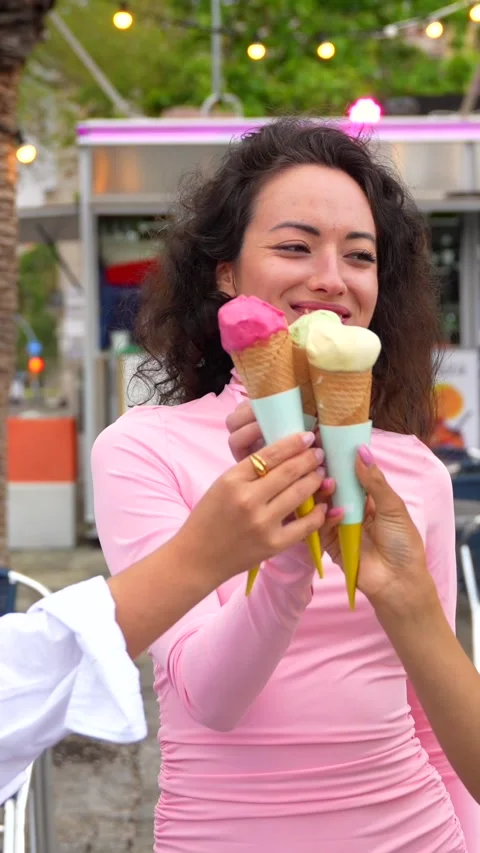Women eating ice cream next to shop in t... | Stock Video | Pond5