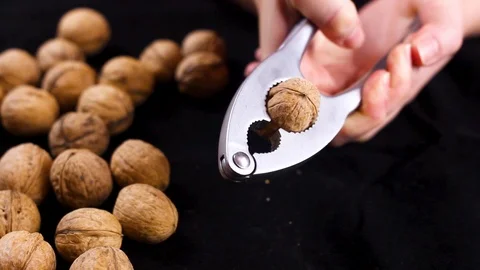 Women's hands crush the walnut on black ... | Stock Video | Pond5